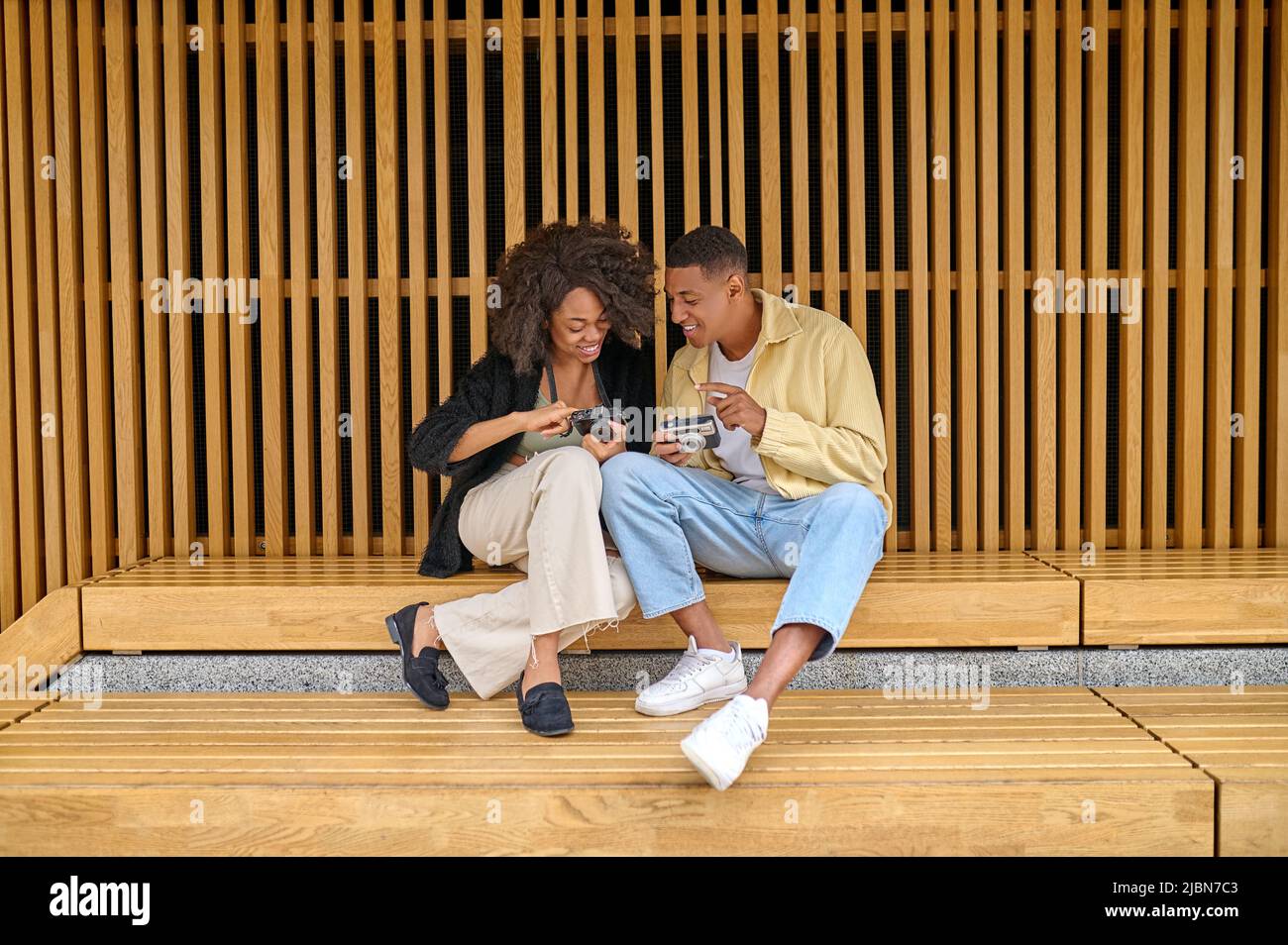 Guy and girl sitting and staring at camera Stock Photo - Alamy