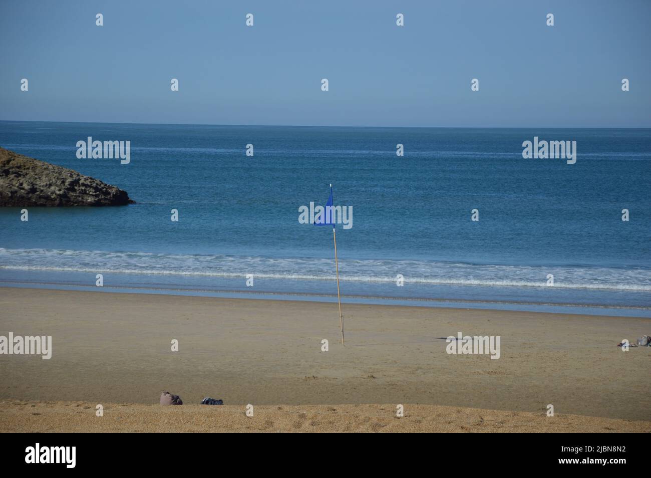 Blue safety flag on the beach Stock Photo - Alamy
