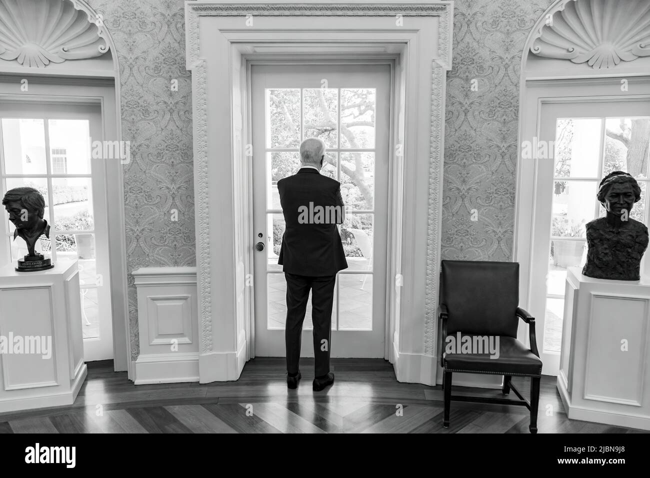 President Joe Biden looks out the window of the Oval Office, Friday ...
