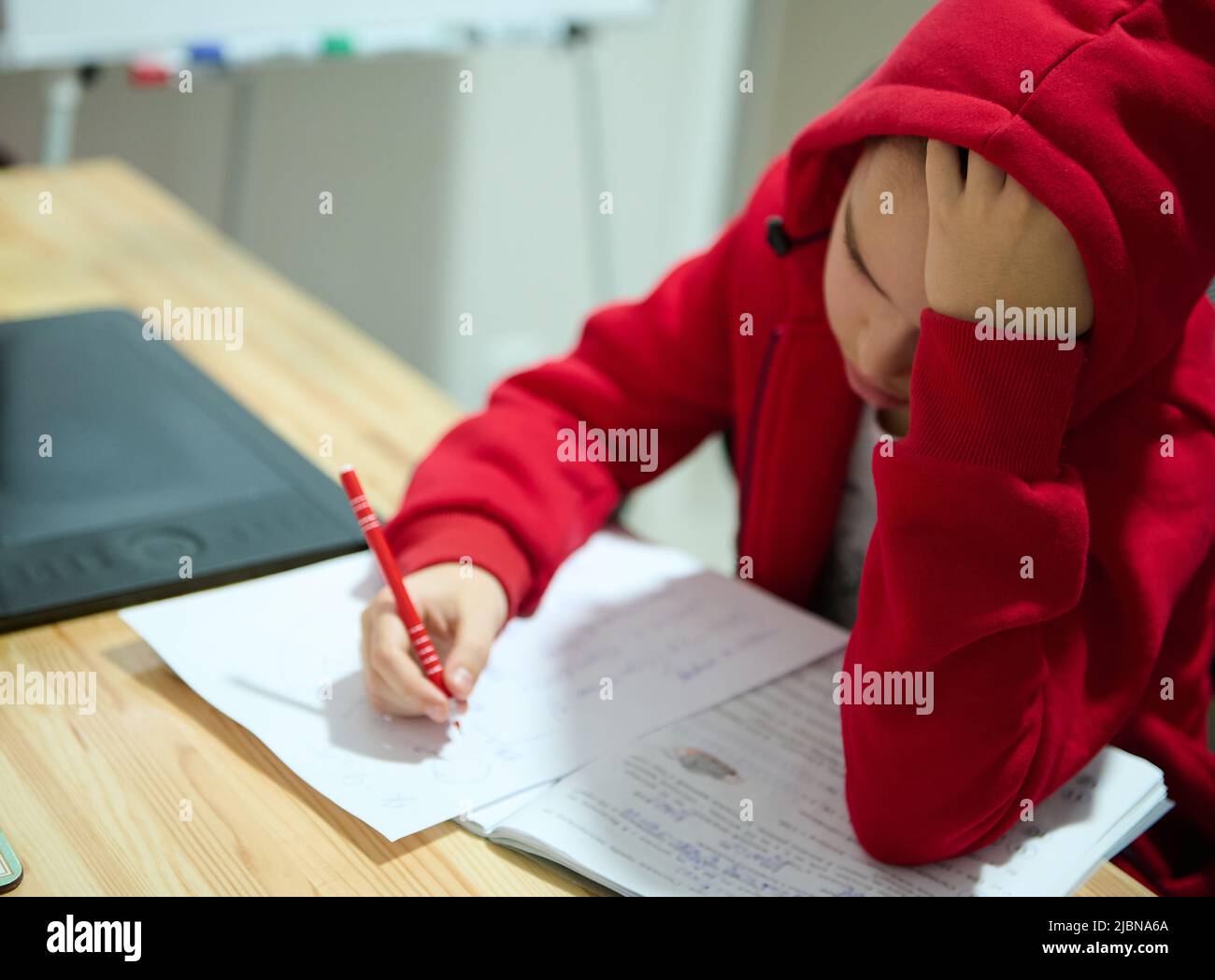 Concentrated preadolescent school boy solving math problems while doing ...