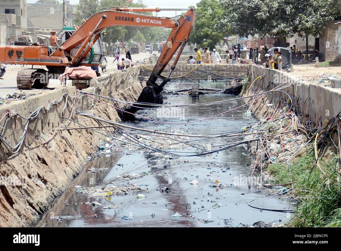 Heavy machinery busy in cleaning the main sewerage drain during a ...
