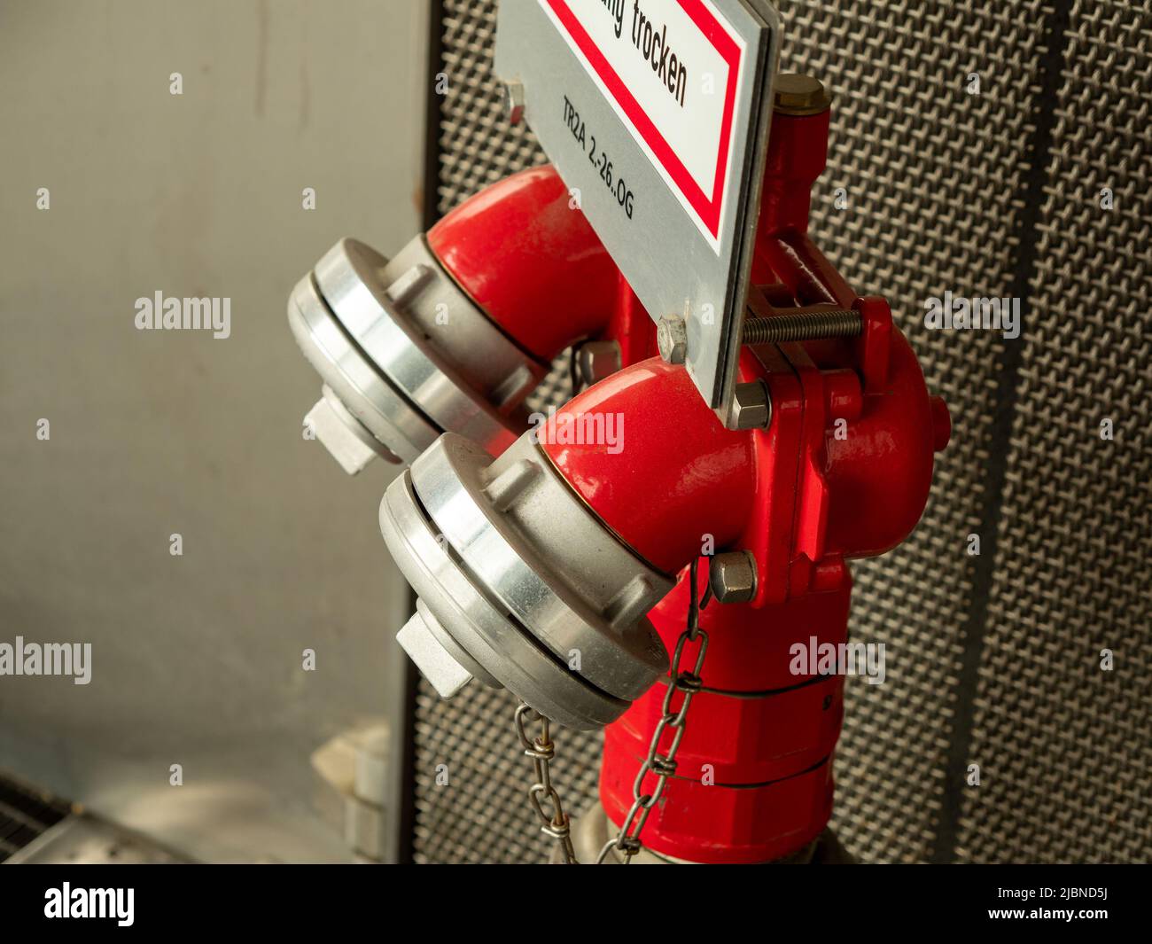 Fire hydrant at the building. Red hydrant Stock Photo - Alamy