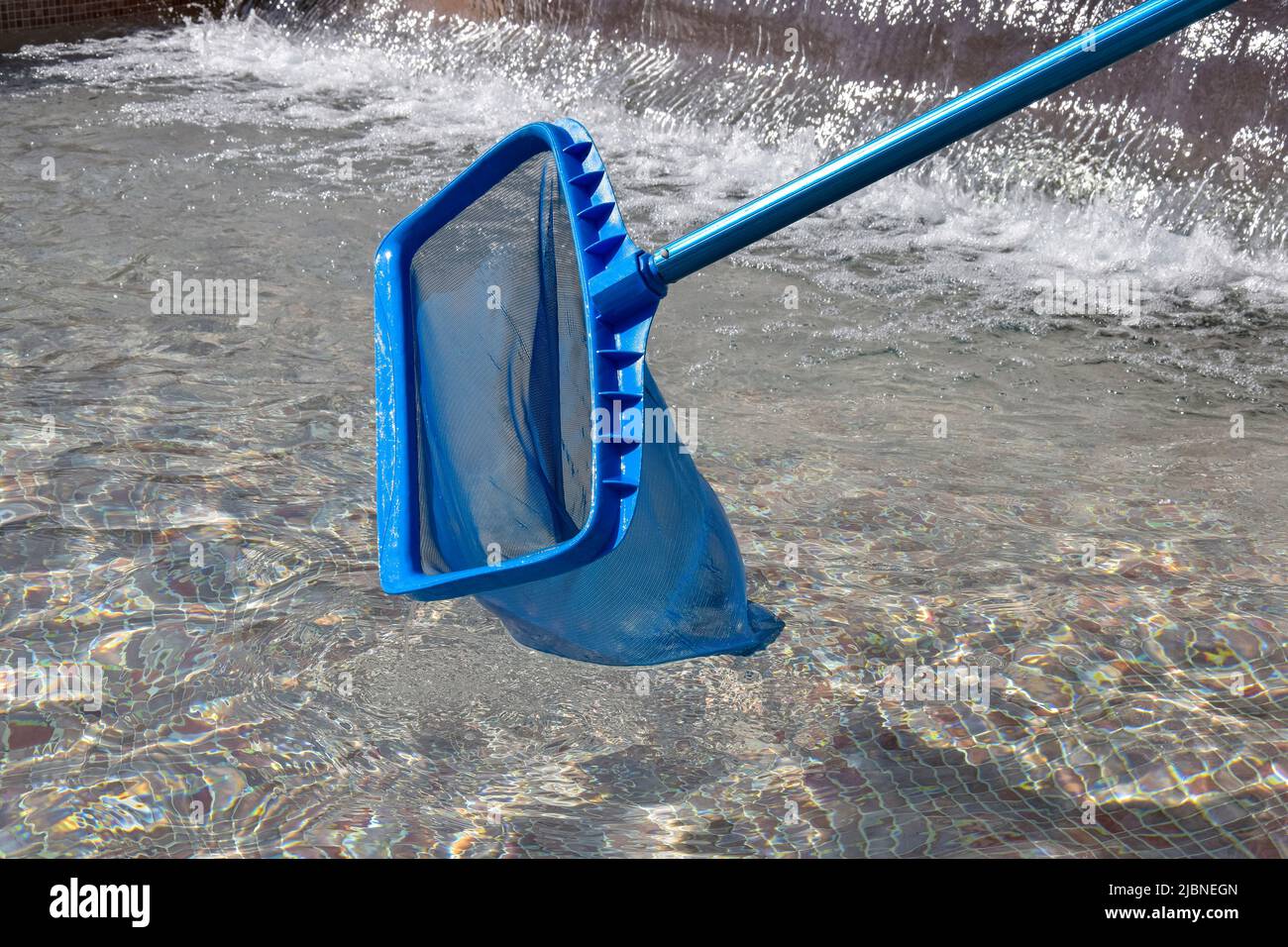 Cleaning pool, city fountain from garbage with special net. Clear water ...