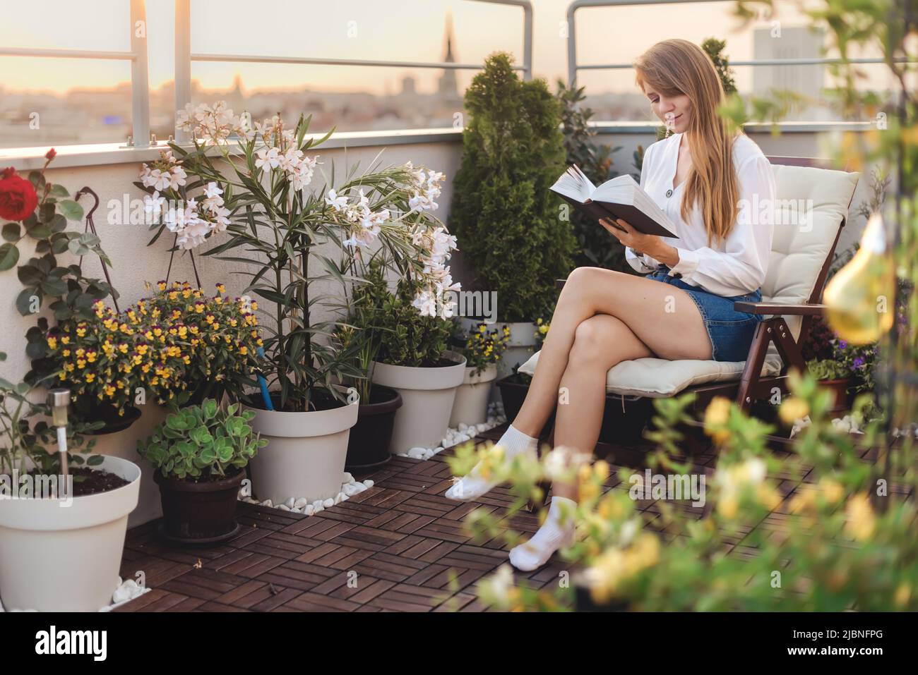 Girl reading book on balcony hi-res stock photography and images - Alamy