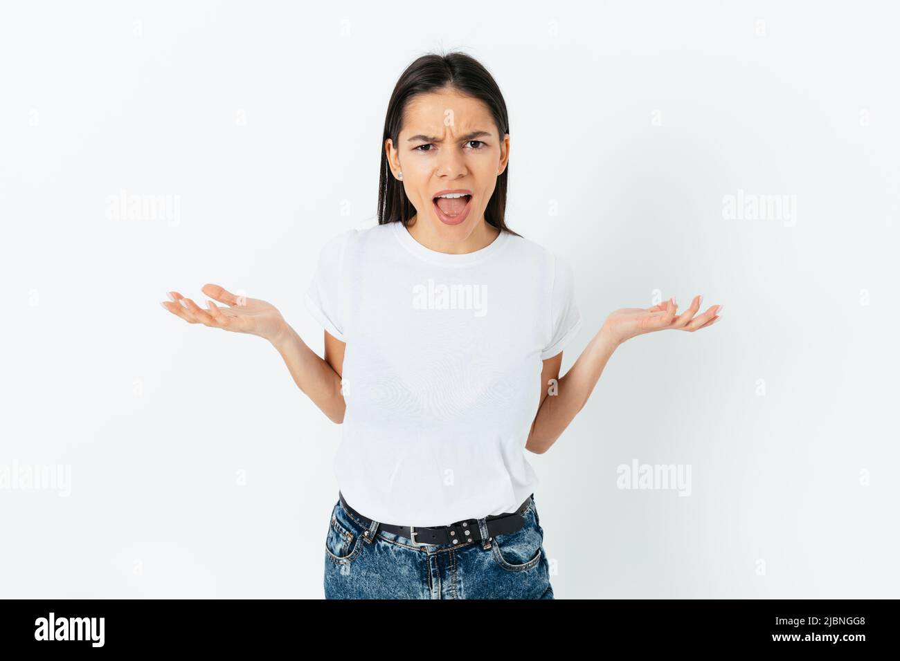 Portrait irritated angry young brunette woman shouting at camera throws ...