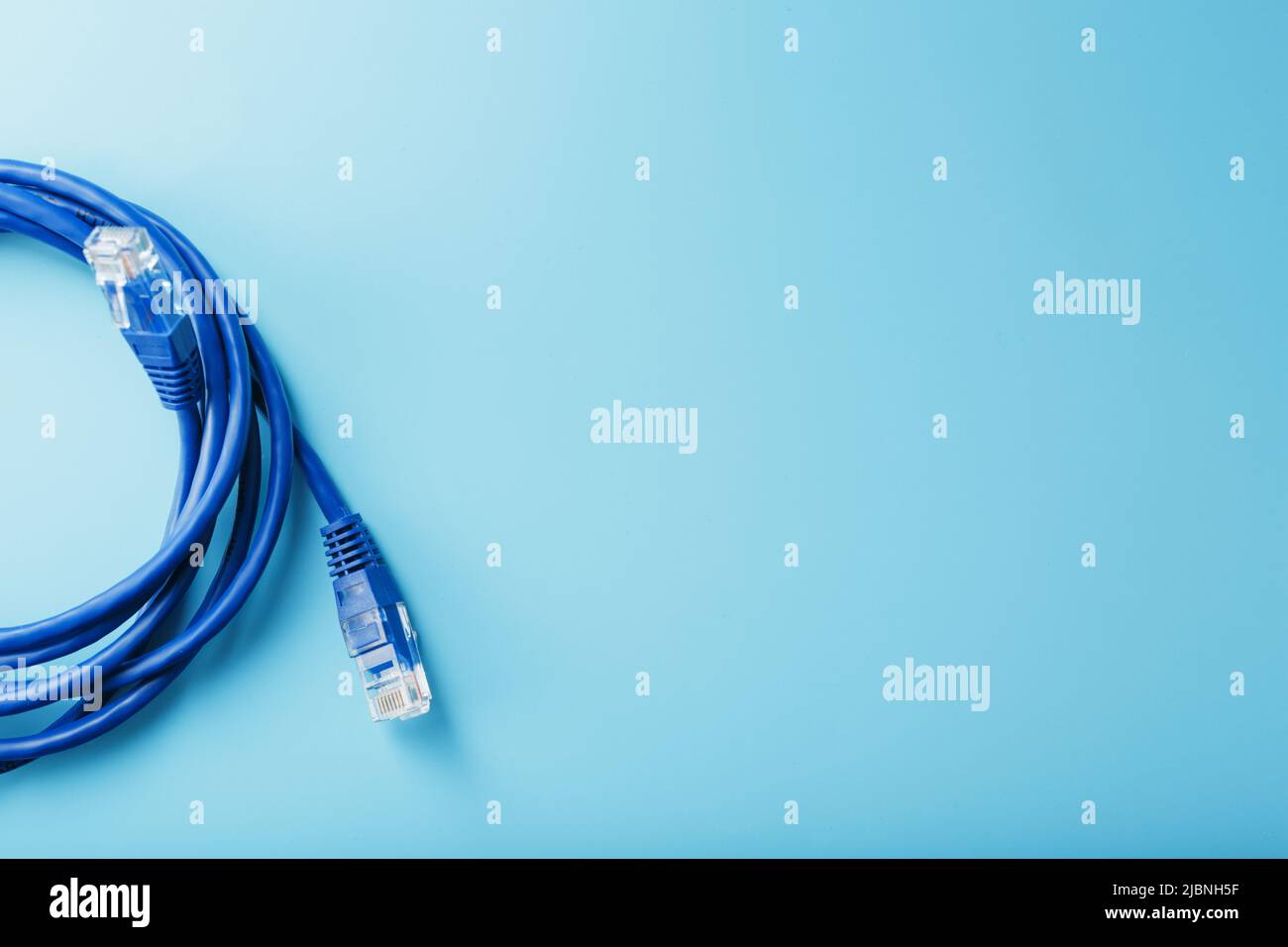 Blue Ethernet Cable Connectors Patch cord cord close-up isolated on a blue background with free ...