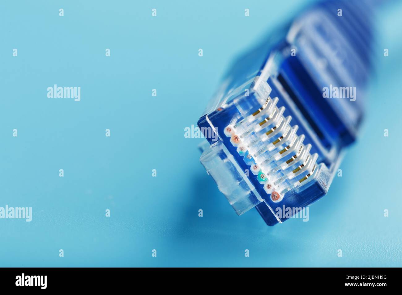 A coil of an Internet network cable for data transmission on a blue ...