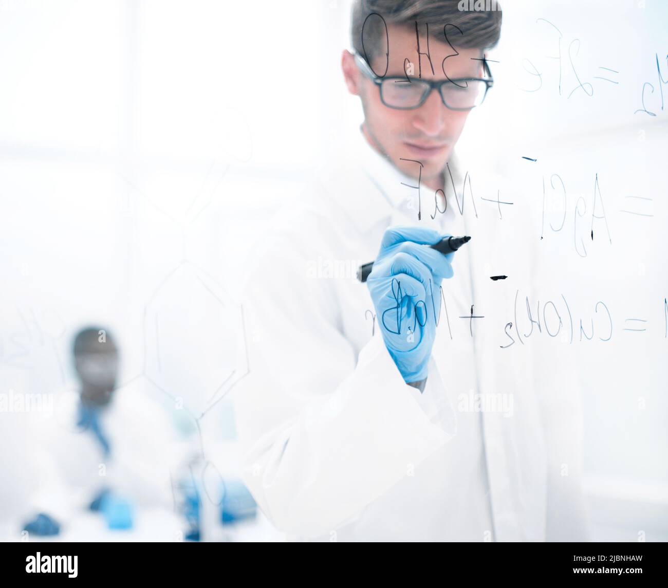 scientist making notes on the glass Board at the time of the experiment ...