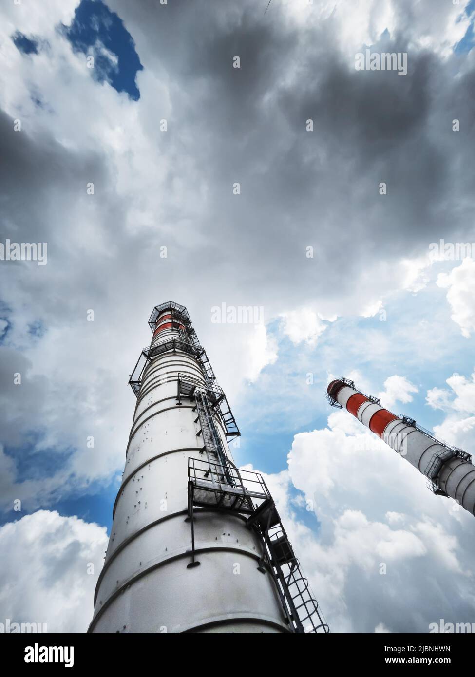 White chimneys of a power plant on a background of clouds with diagonal ...