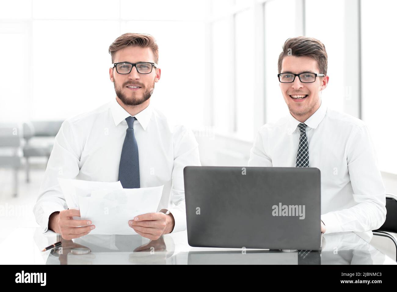 happy employees sitting at a table in a new office Stock Photo - Alamy