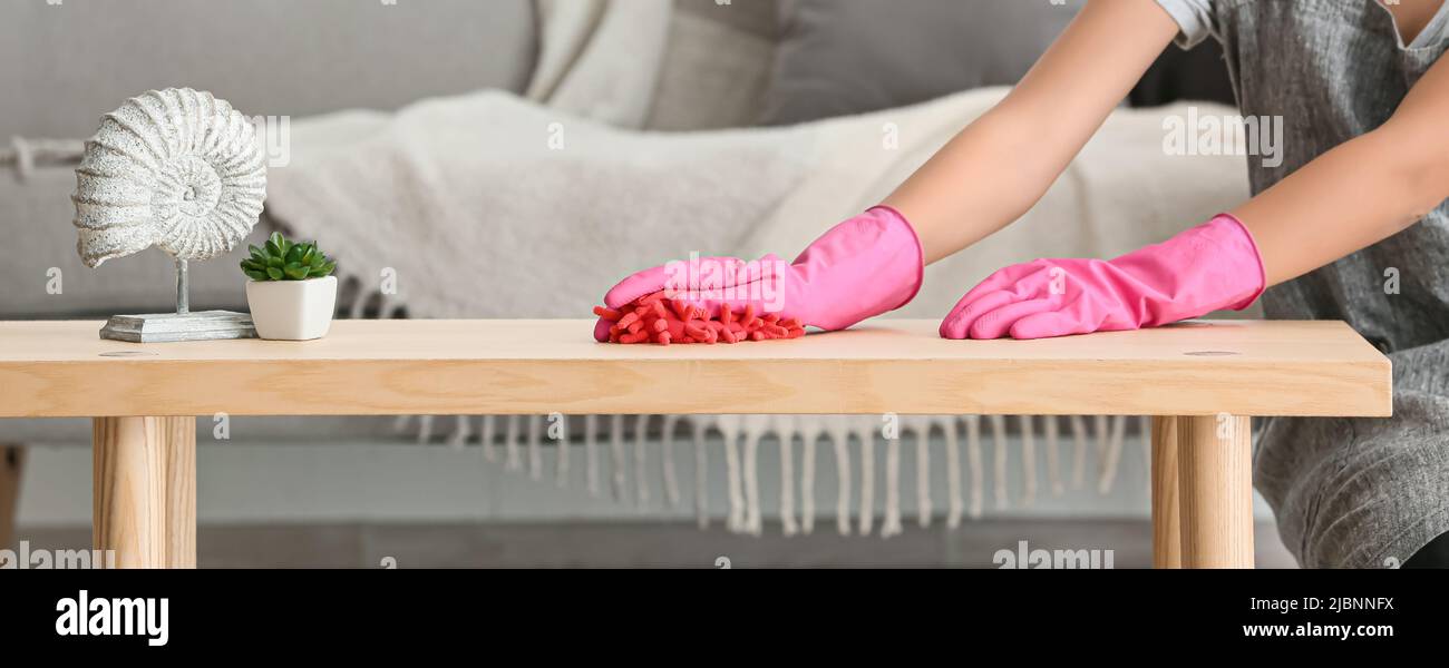 Young woman wiping dust from table in her flat Stock Photo - Alamy