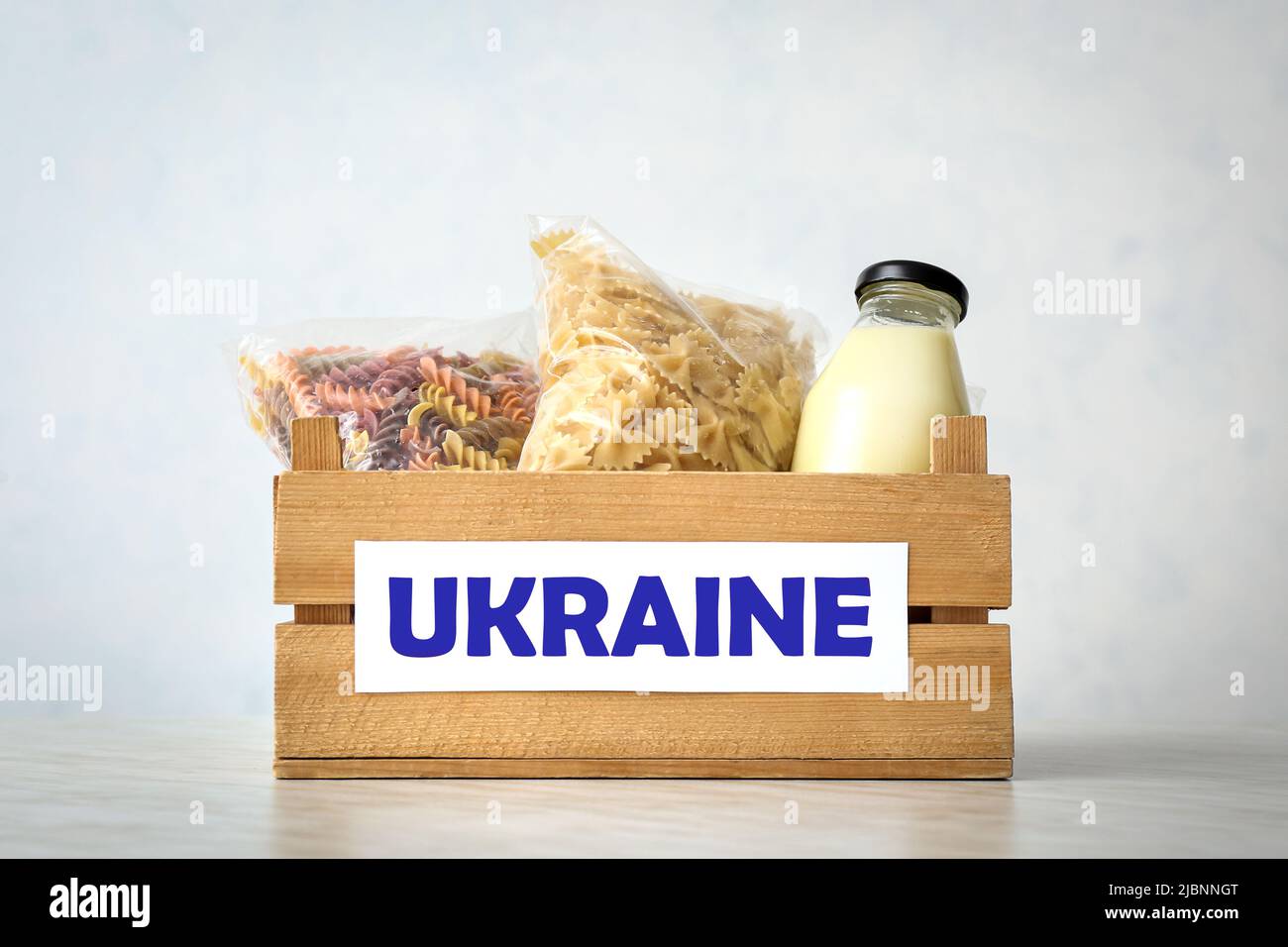 Box with food on light background. Humanitarian aid for Ukraine Stock ...