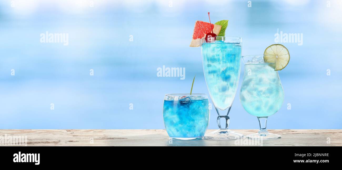 Glasses of cold Blue Lagoon cocktail on edge of swimming pool Stock ...