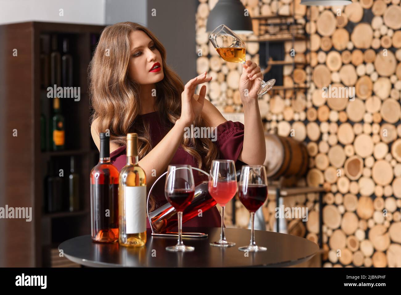 Beautiful young female sommelier tasting types of wine Stock Photo - Alamy