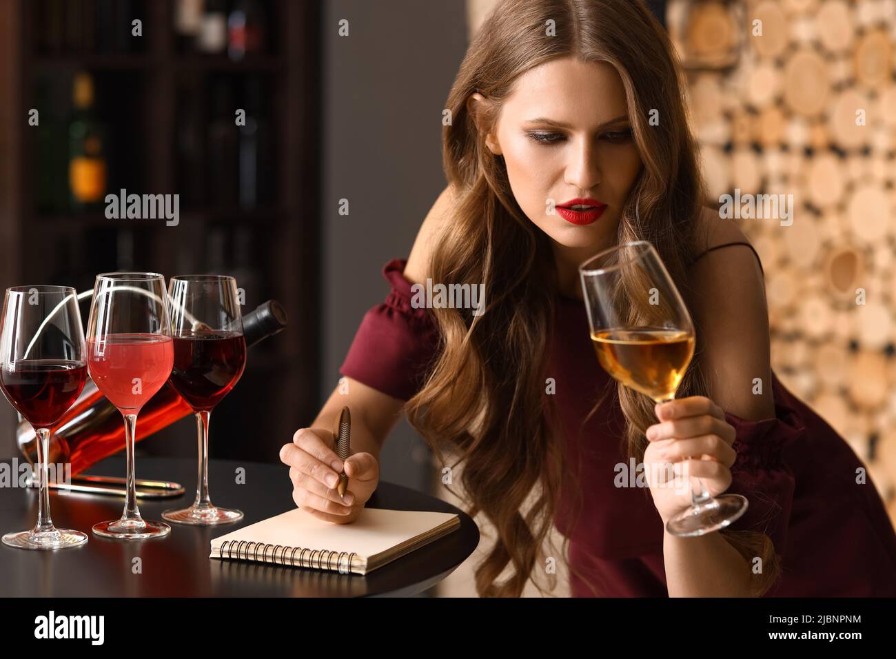 Beautiful young female sommelier tasting types of wine Stock Photo - Alamy