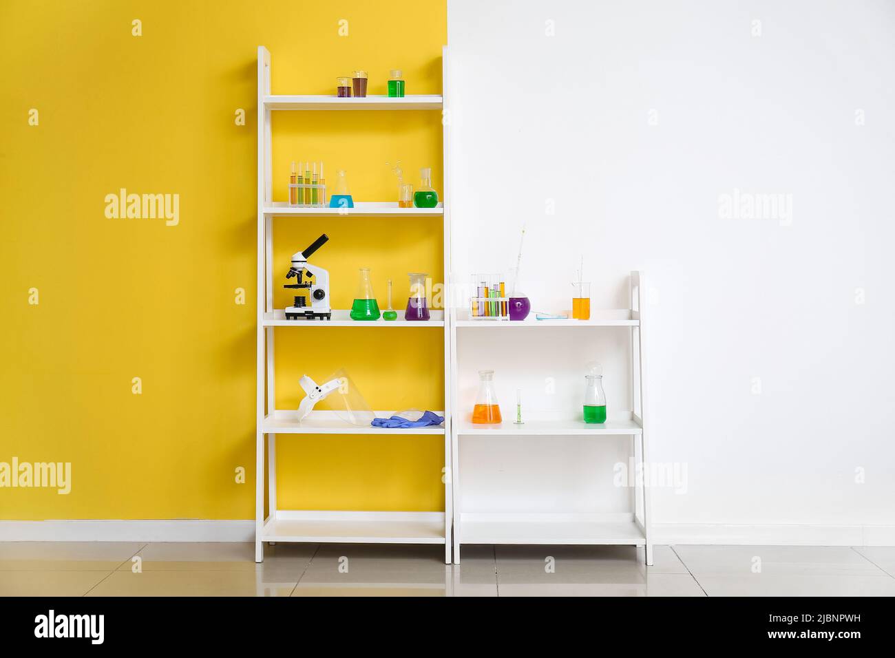 Shelving unit with different laboratory glassware and microscope near ...