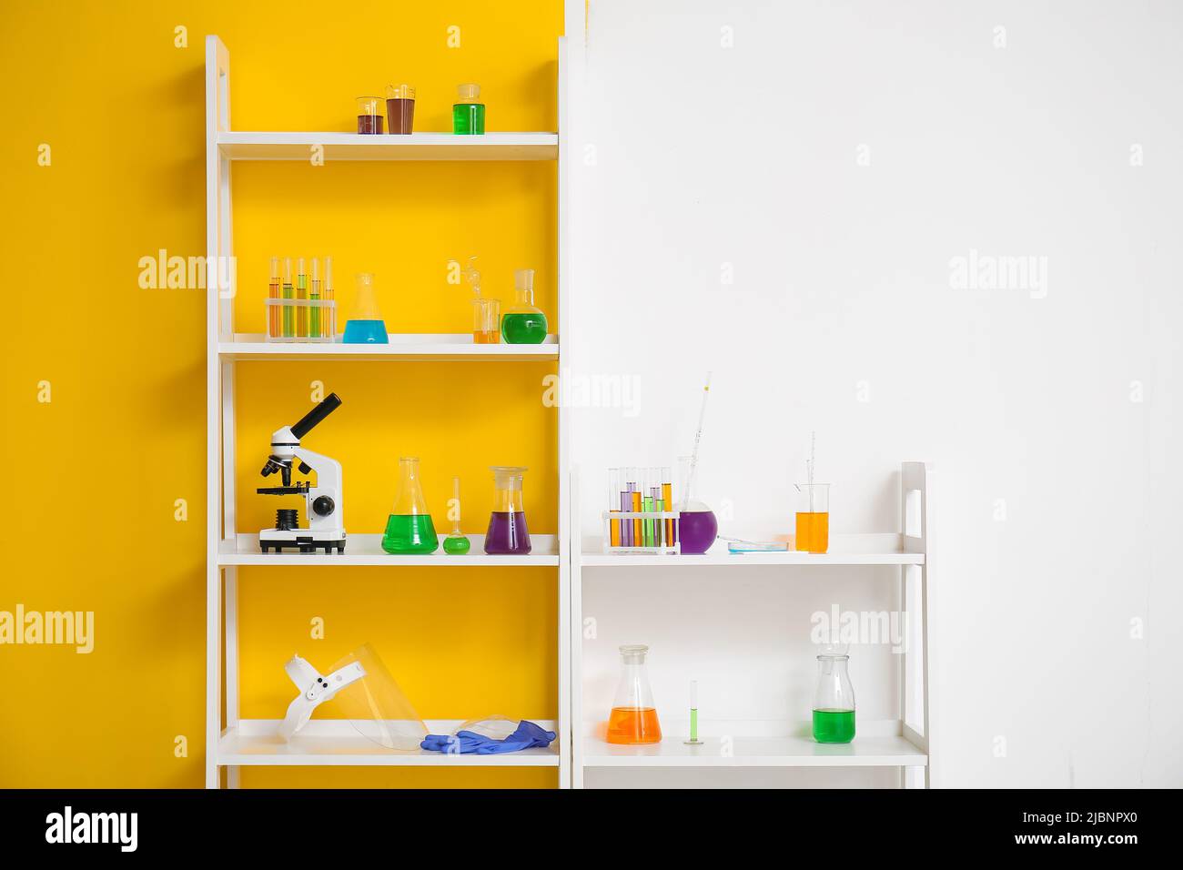 Shelving unit with different laboratory glassware and microscope near ...