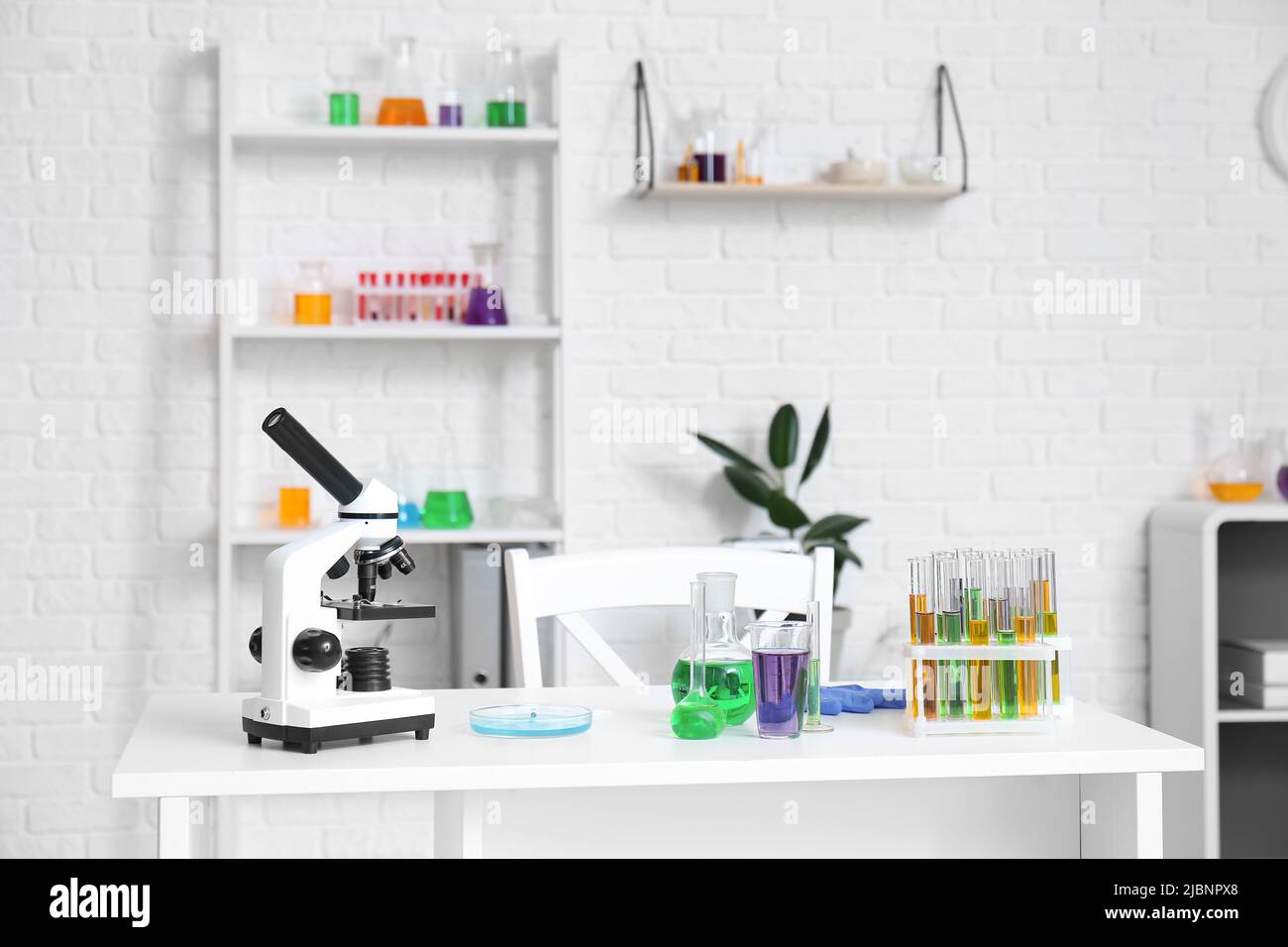 Modern workplace with microscope and chemical glassware in medical ...
