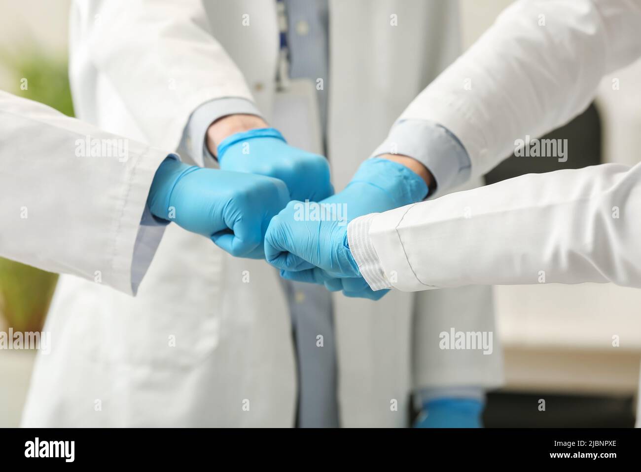 Group of doctors putting hands together in clinic Stock Photo - Alamy
