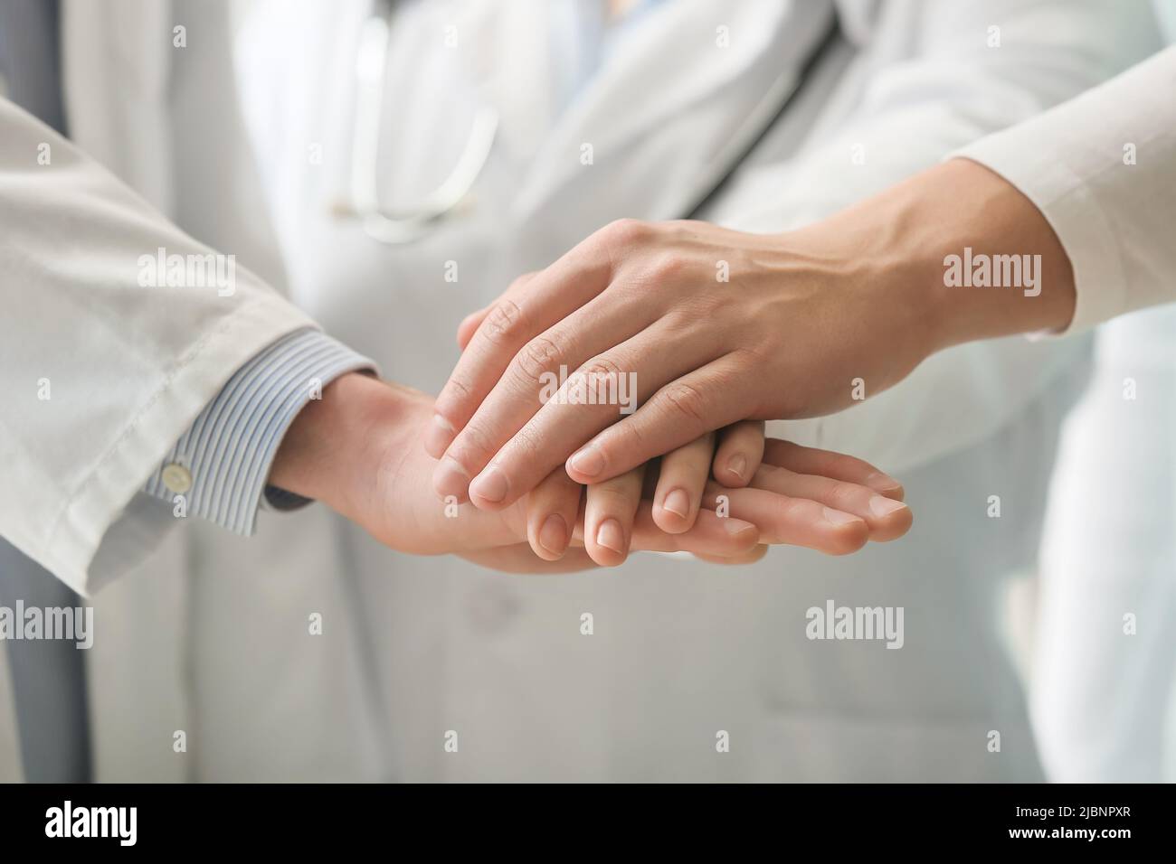 Group of doctors putting hands together in clinic, closeup Stock Photo ...