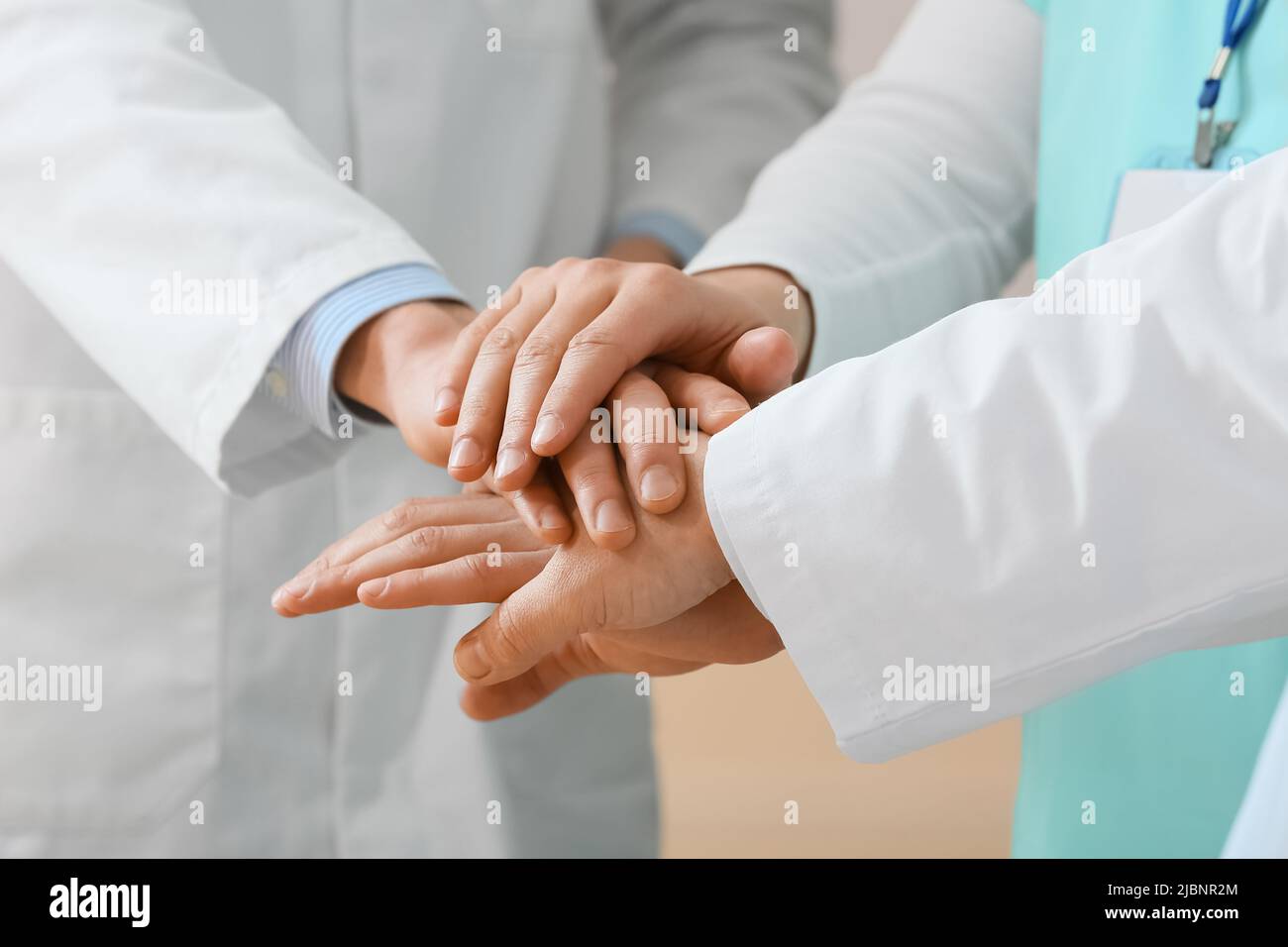 Group of doctors putting hands together in clinic, closeup Stock Photo ...