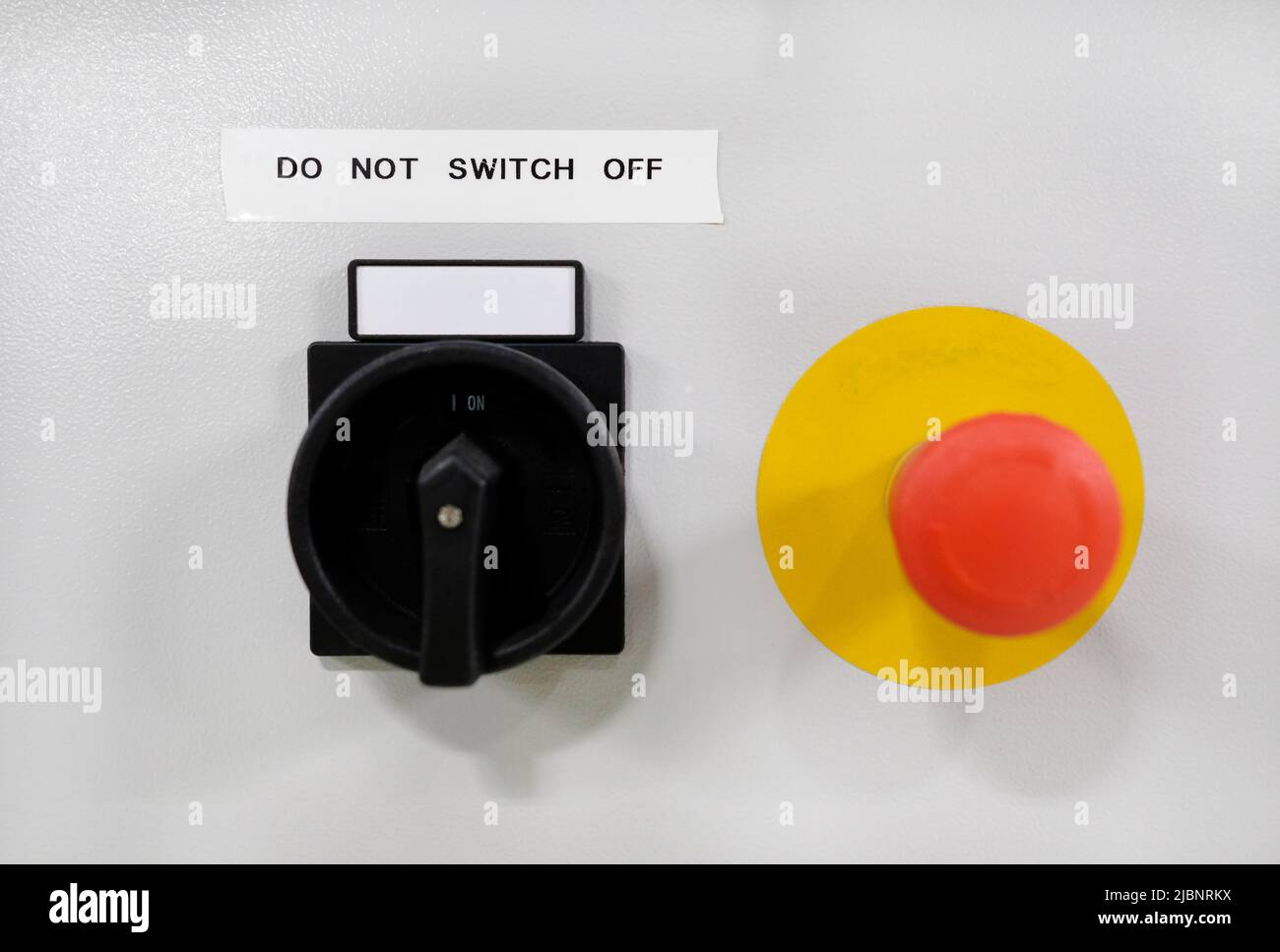 A button and a switch next to a sign reading "DO NOT SWITCH OFF Stock ...