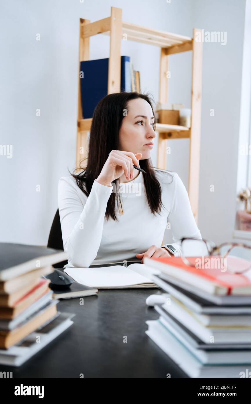 Female Accountant working with many books and notepads on the ...