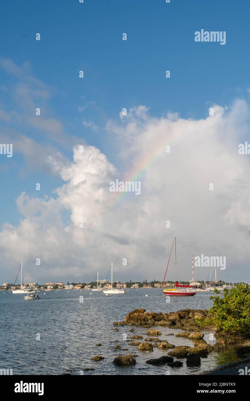 Sailboats in beautiful tropical harbor with dramatic clouds and rainbow ...