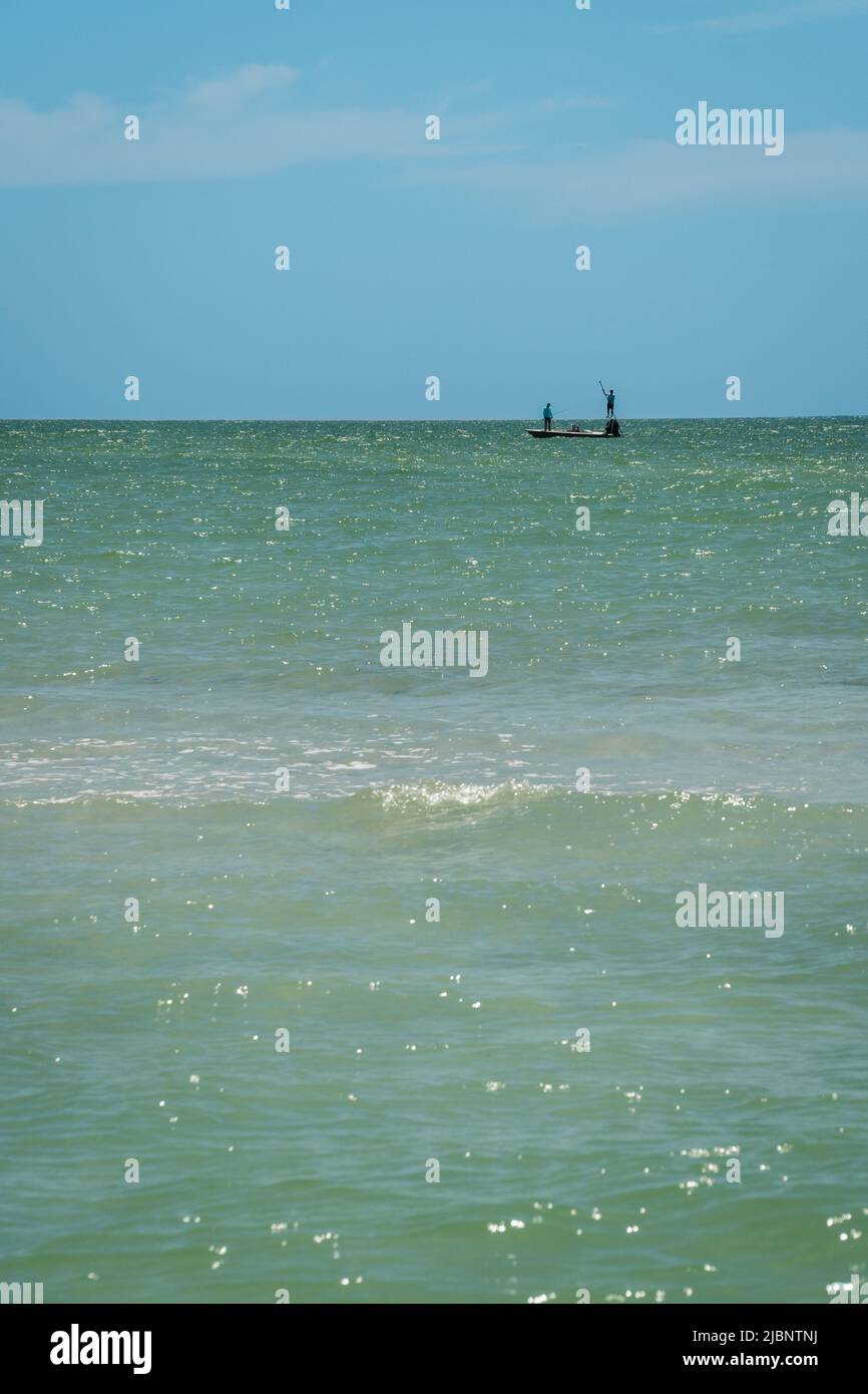 Silhouette of row boat in distance on beautiful blue ocean with copy ...