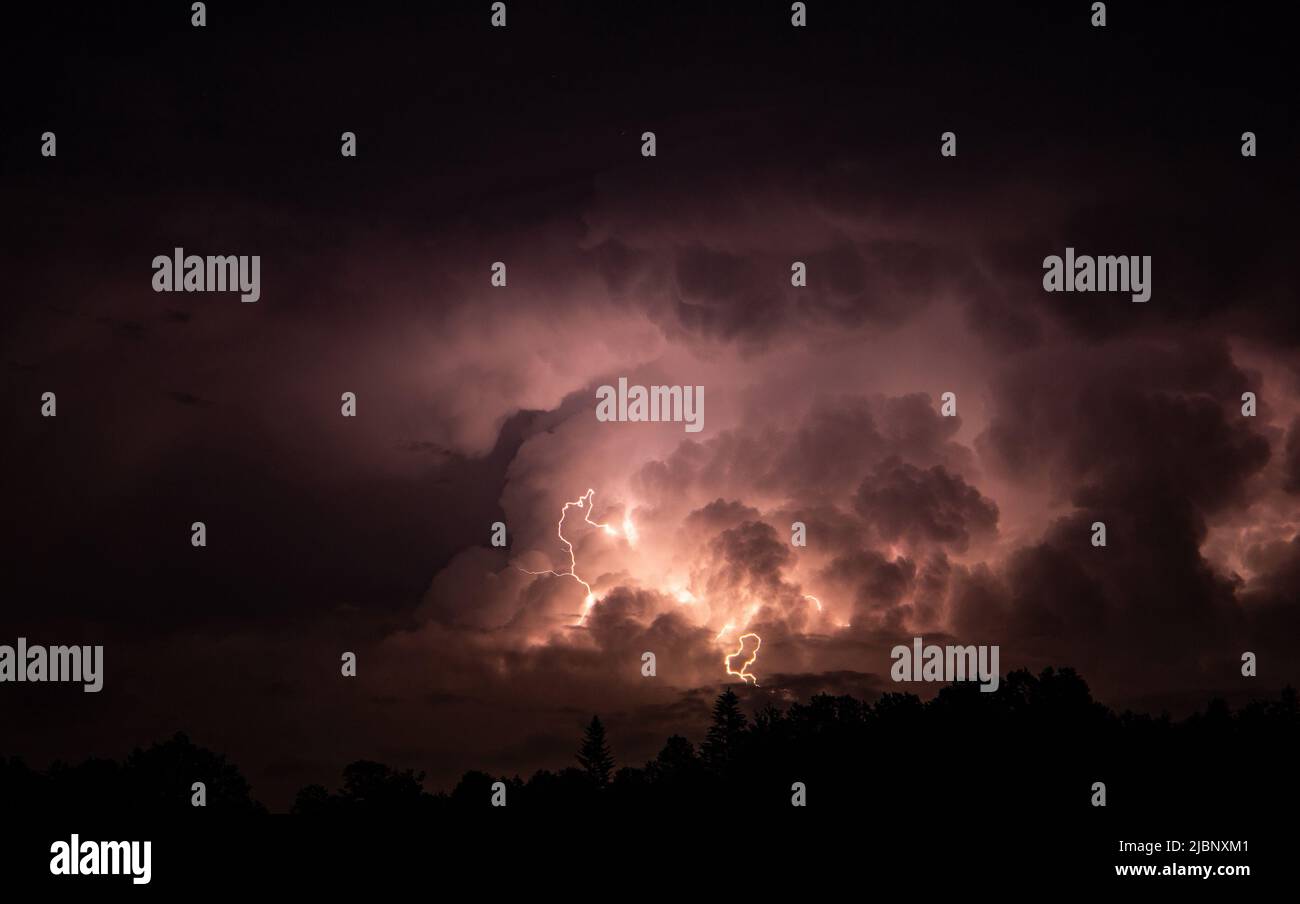 Lightning in the sky during a storm at night Stock Photo - Alamy