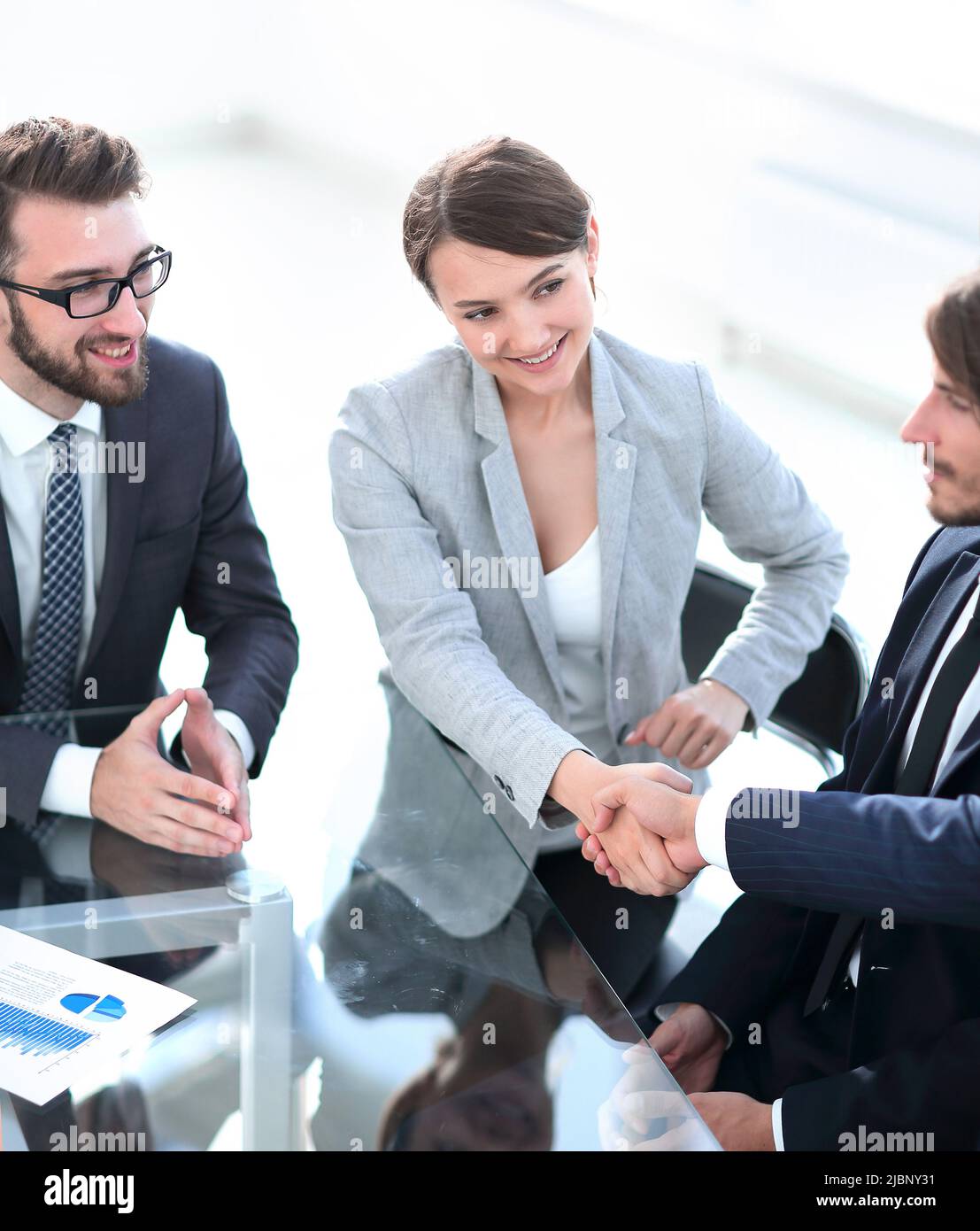 handshake business partners for their Desk Stock Photo - Alamy