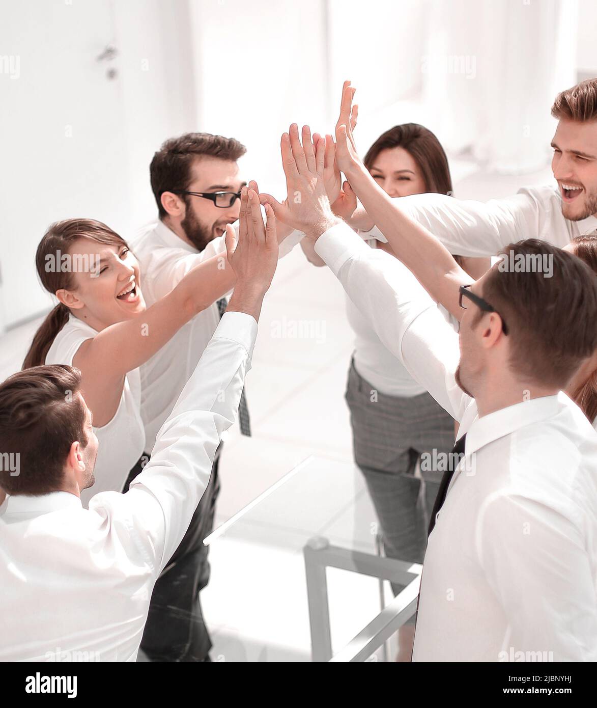 successful business teams make a high five over their Desk Stock Photo ...