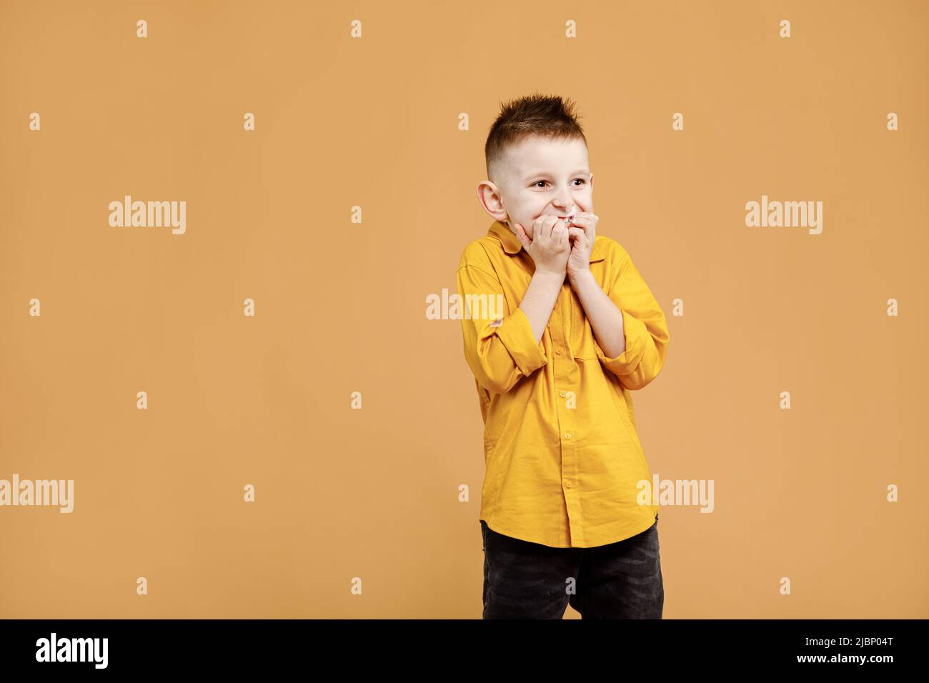 portrait of caucasian scared child boy on yellow background. amazed ...
