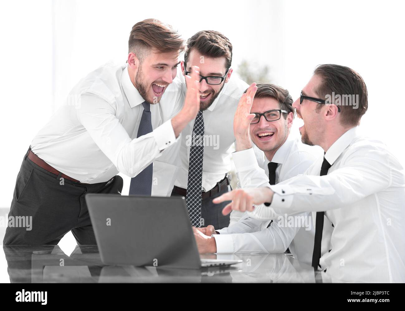 Happy excited team looking at the laptop screen Stock Photo - Alamy