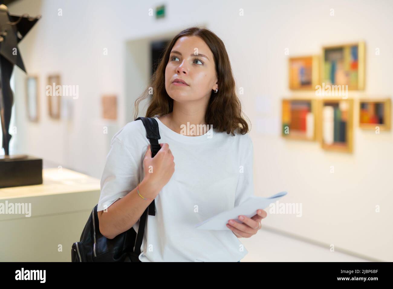 Focused girl visitor examines an exhibit in an art gallery Stock Photo ...
