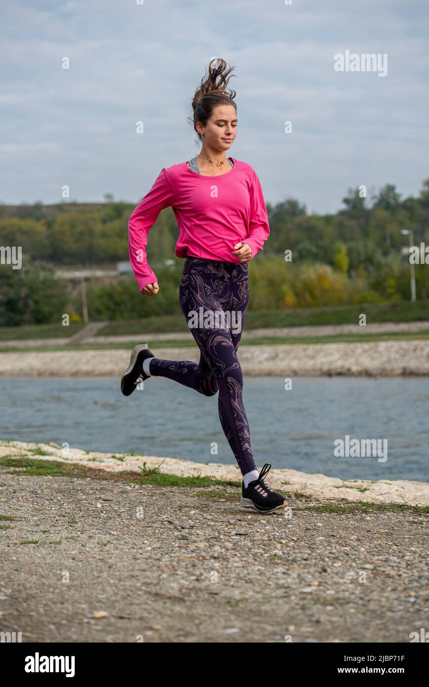 Beautiful and attractive fit girl is running fast while enjoying the ...