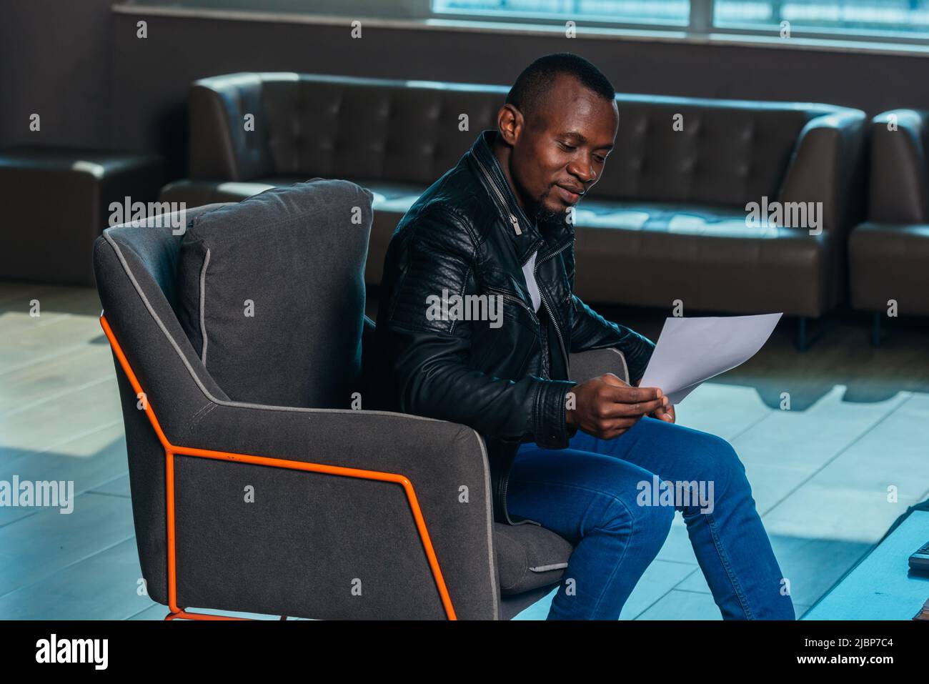Portrait of an African-American businessman sitting in a modern office ...