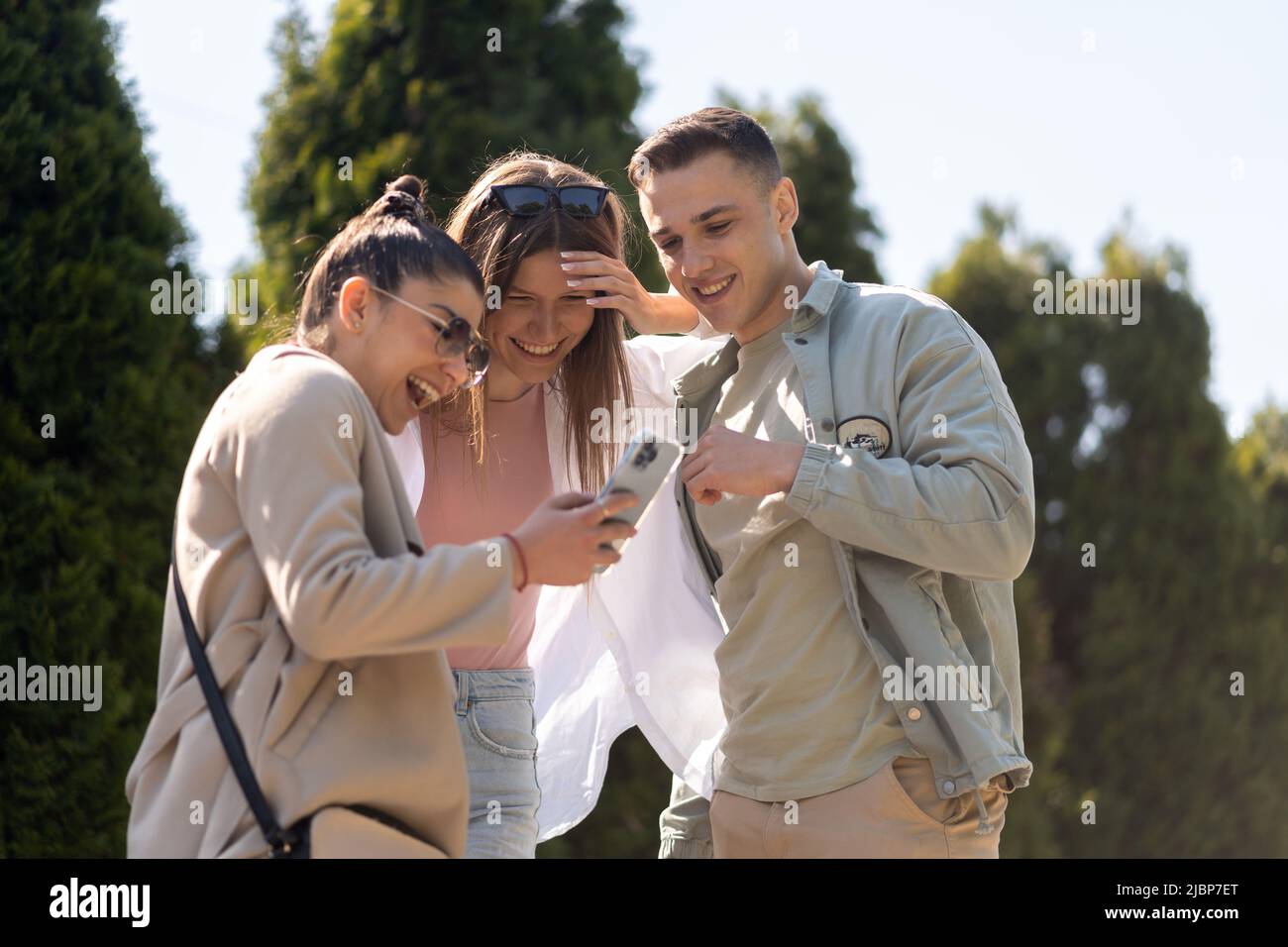Happy young student people watching the smartphones Stock Photo - Alamy