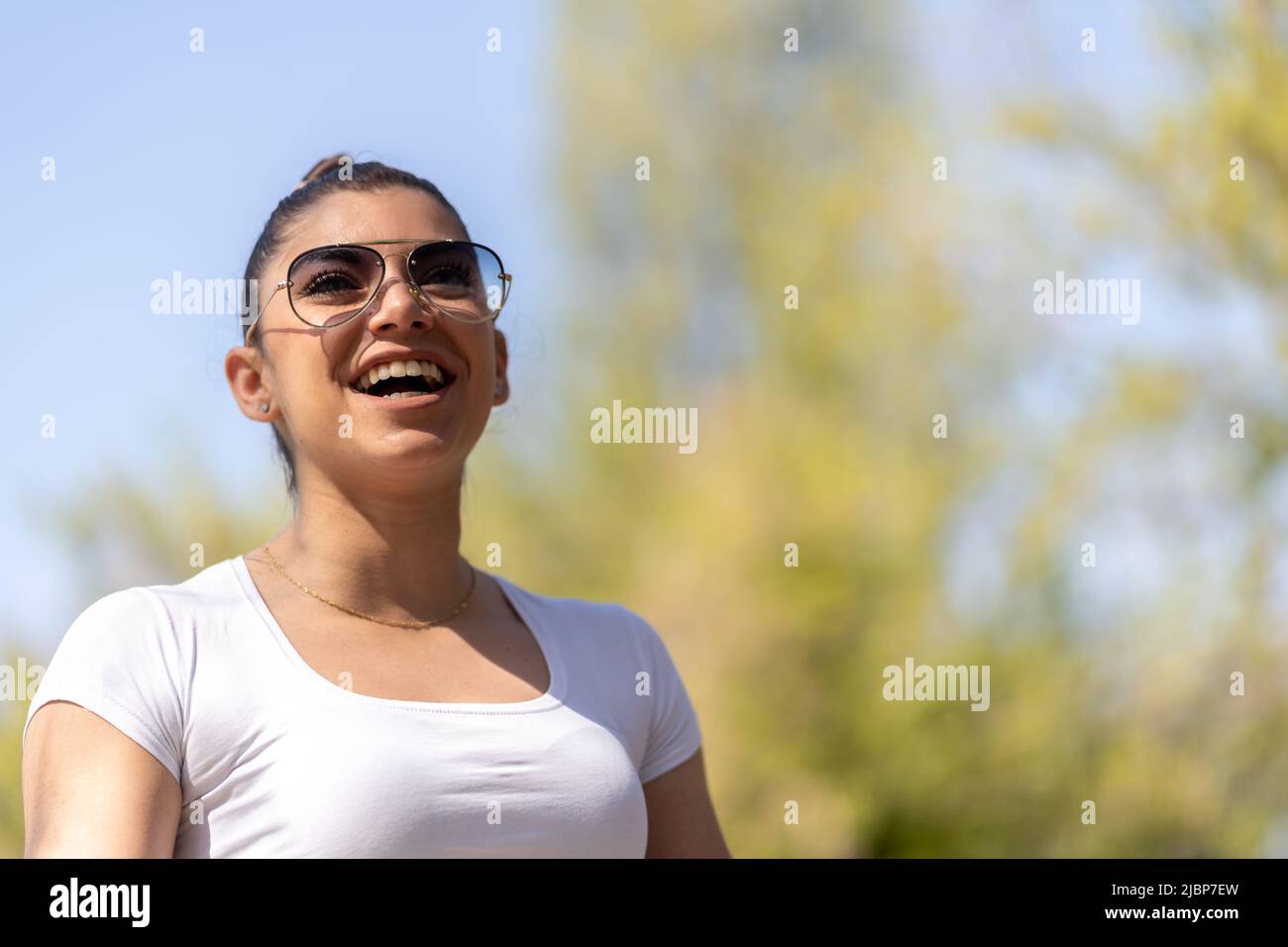 Attractive young woman walking by herself in center of city in summer ...