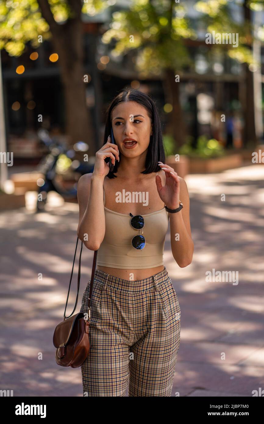 Attractive businesswoman is being mad while she talks on the phone with ...