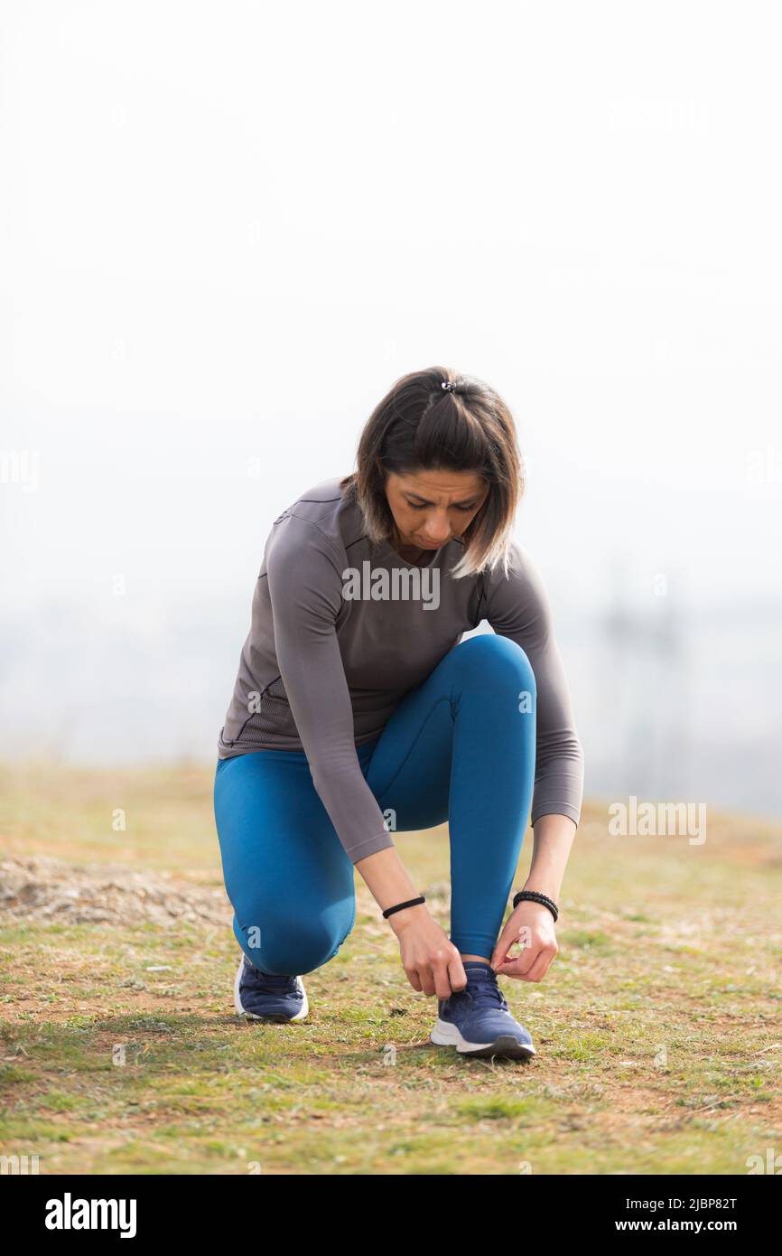 Amazing and active woman is tieing her shoes before training Stock ...