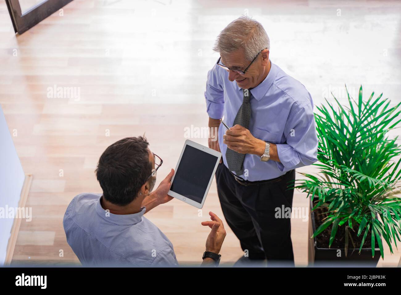 Two senior businessmen are talking and laughing in the office, high ...