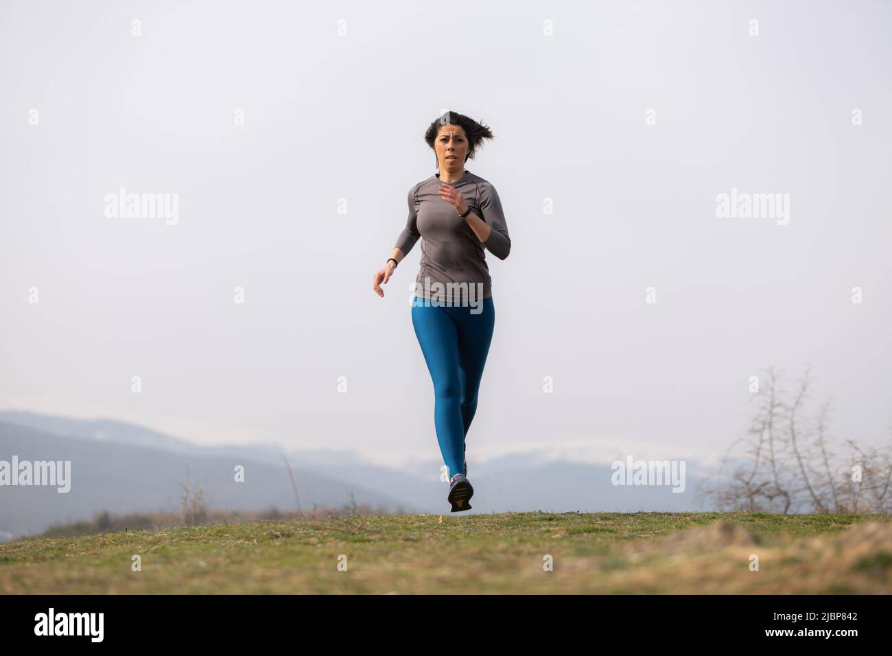 Amazing and active woman is running while looking at the camera Stock ...