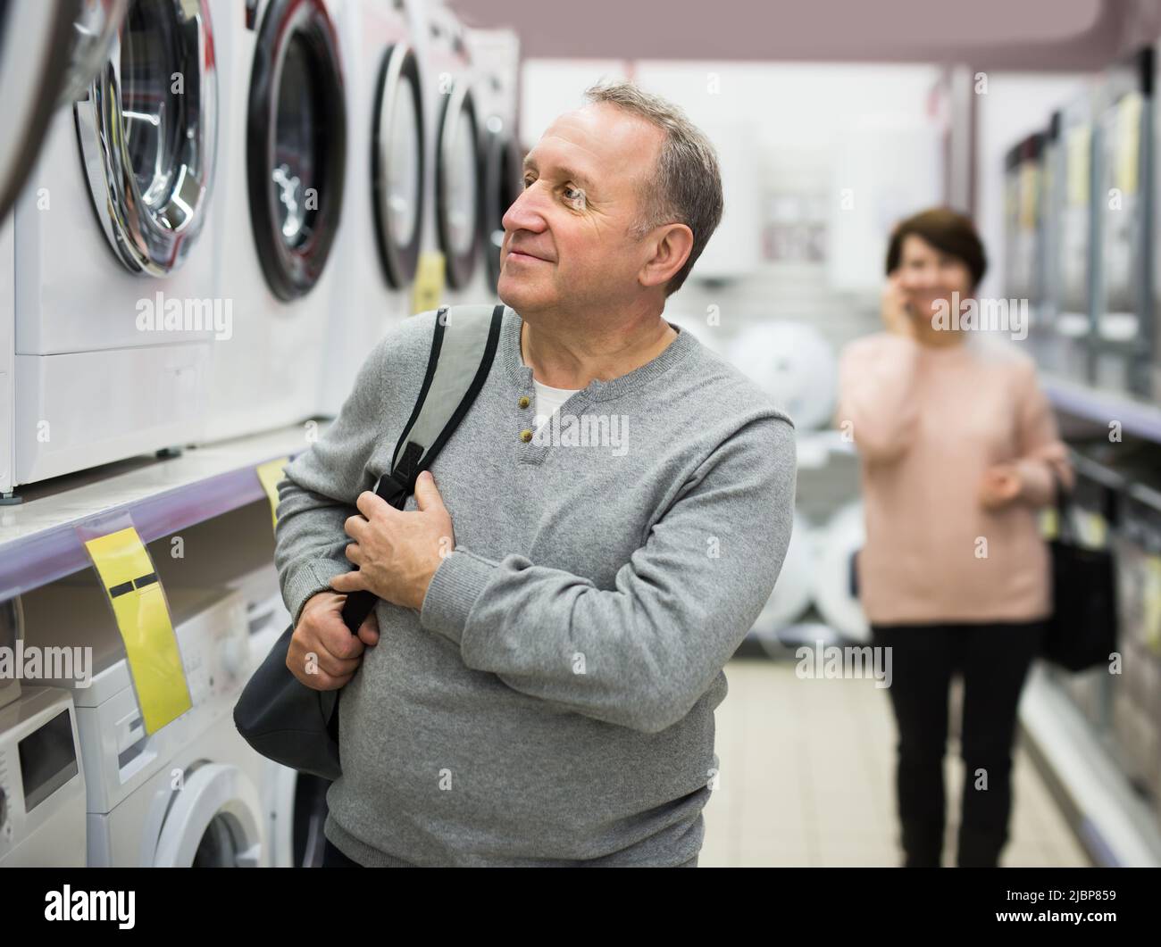 European man chooses a washing machine Stock Photo - Alamy