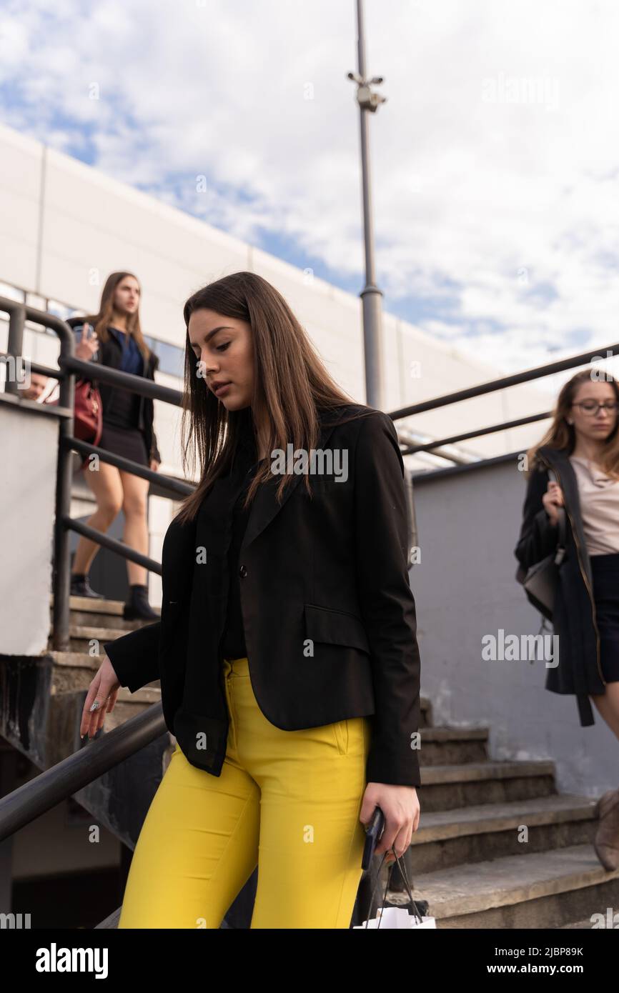 Three amazing and attractive businesswomen are walking down the stairs ...