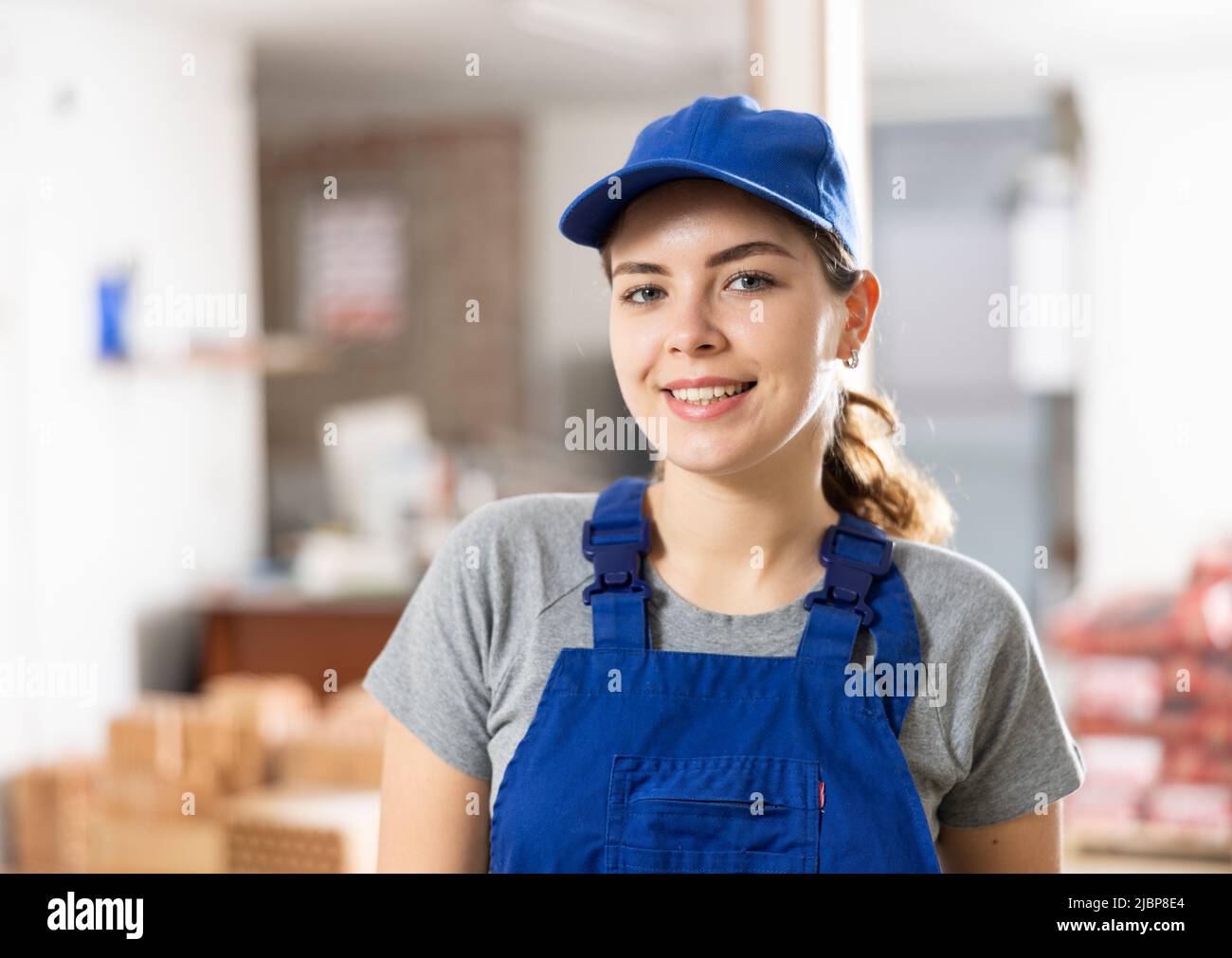 Portrait of positive woman builder standing in construction site Stock ...