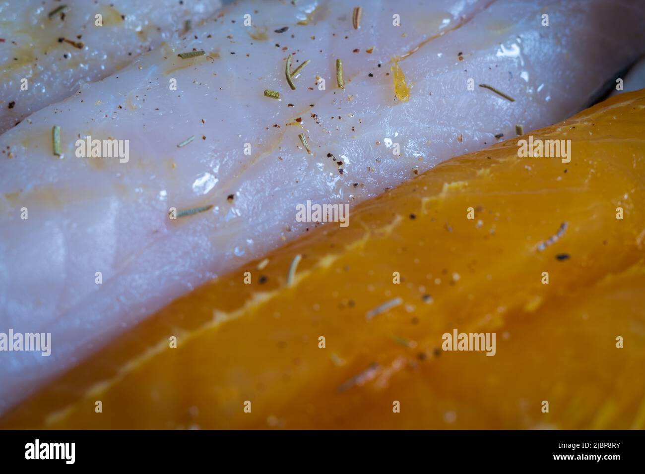 Raw seasoned fish fillets on baking tray closeup Stock Photo - Alamy