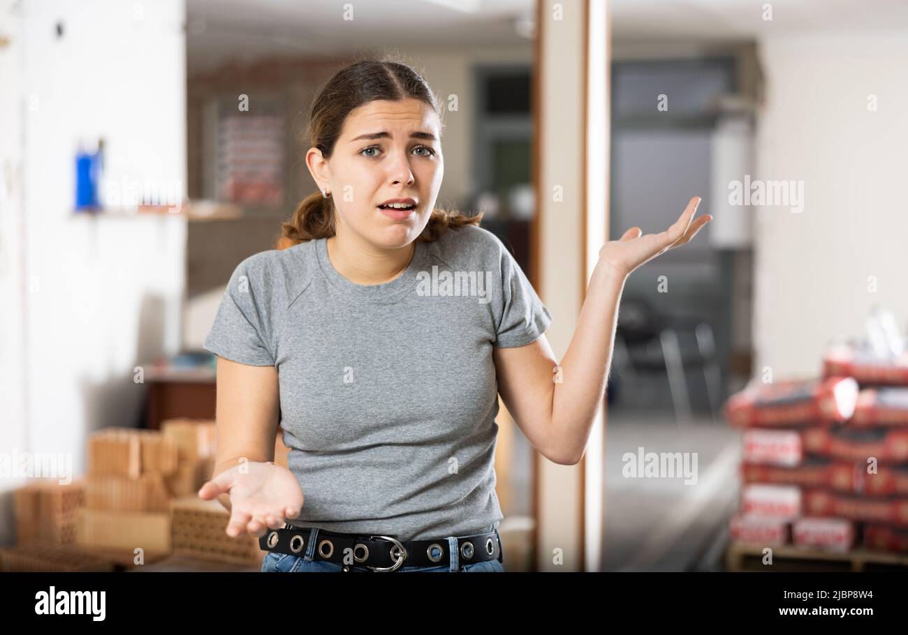 Stressed woman standing on indoor construction site Stock Photo - Alamy