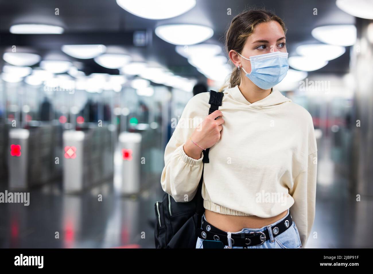 Confident girl in a protective mask entered the subway, passing through ...