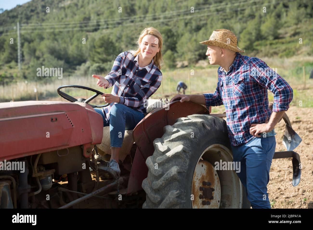 Positive woman working on small farm tractor Stock Photo - Alamy